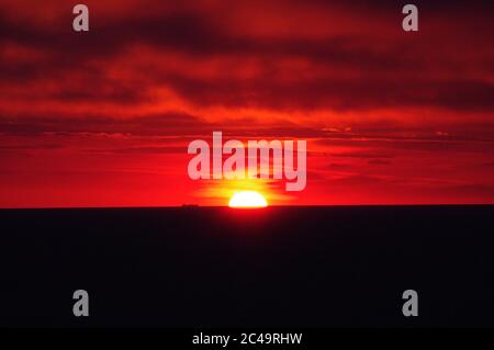 Sequence of Images of a Sunset, Fiery Red sunset over dark sea with ...