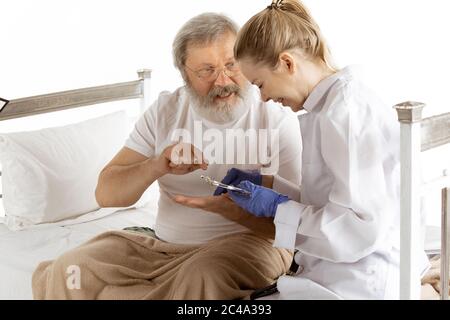 Elderly old man recovering in a hospital bed isolated on white ...