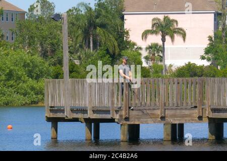 A man is fly fishing or spinning on a mountain lake. Recreational ...