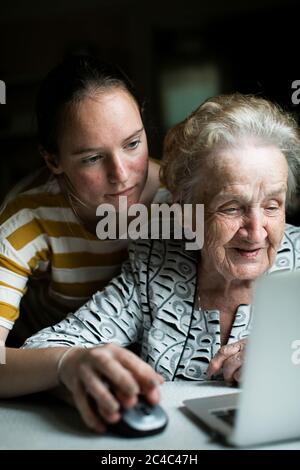 A girl teaches her grandmother how to use the computer Stock Photo - Alamy