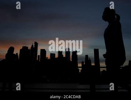 The sun sets behind part of the Manhattan skyline during the fourth ...