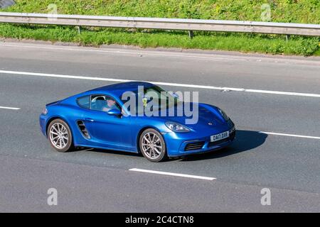 Side view of a blue porsche 718 Cayman GTS in a white background, black ...