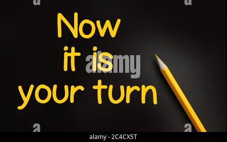 Now it is your turn words and yellow pencil on black background ...