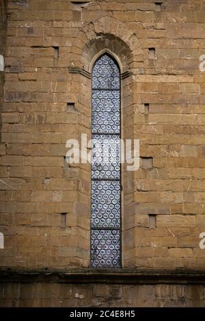 A narrow stained glass window in the church of St Mary and St Peter ...