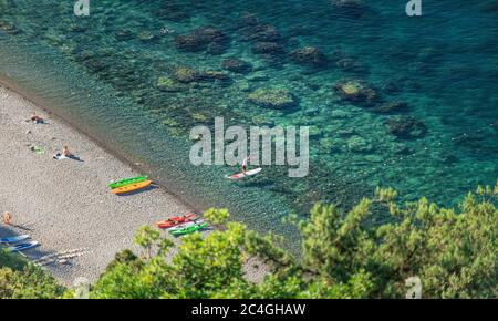 Strong men floating on a SUP boards in a beautiful bay on a sunny day ...