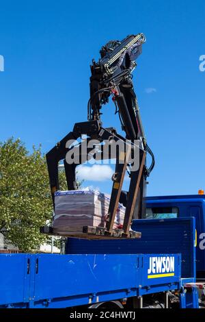 Mechanical unloading Jewson lorry truck of load of insulation blocks ...