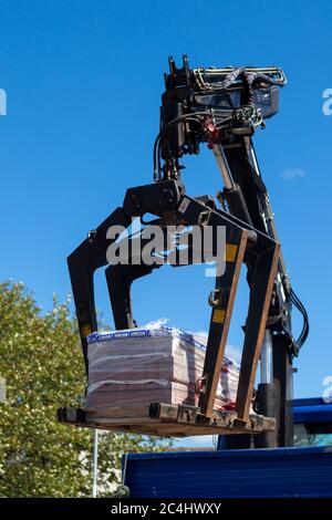 Mechanical unloading lorry truck of load of concrete blocks lifted off ...