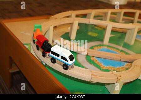 Wooden toy train running on miniature railroad. The black engine ...