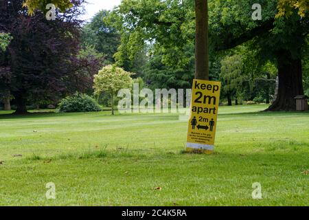 Keep 2 meters apart sign to the right in a park Stock Photo - Alamy