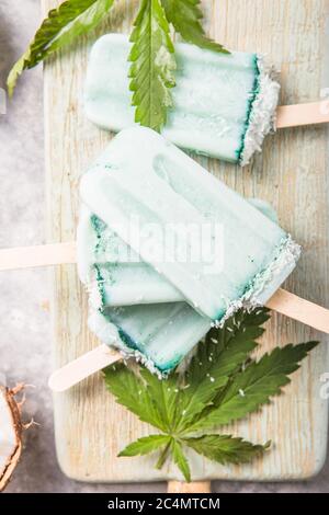 ice cream popsicle bars with coconut slices, cannabis on concrete ...