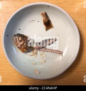 top view of fish skeleton bones and flavor peppers on slate background ...