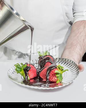 A vertical closeup of a chef pouring sauce on a burrito stack Stock ...