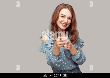 Satisfied smiling brunette girl pointing fingers down, recommend ...