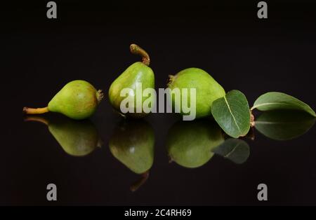 Three pears against a dark studio background, in black and white Stock ...