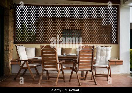 Comfortable chairs around wooden dining table in big house with living ...