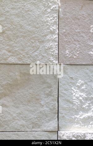 Vertical closeup of a white stone wall under the sunlight at daytime ...