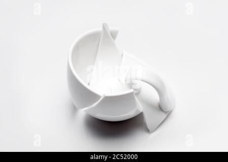 broken white ceramic tea cup on a white background top view, conceptual ...