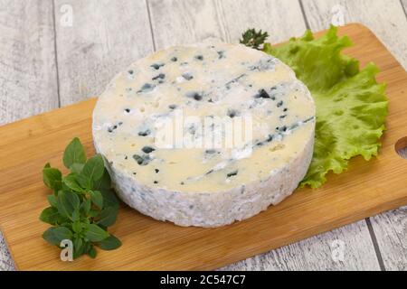 Round blue cheese with salad and basil Stock Photo - Alamy