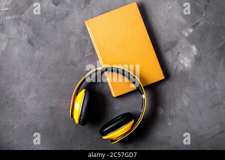 headphones and book connected - audiobook concept on beige desk top ...