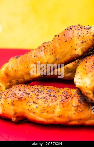 Sausages baked in dough sprinkled with salt and poppy seeds and bowl ...