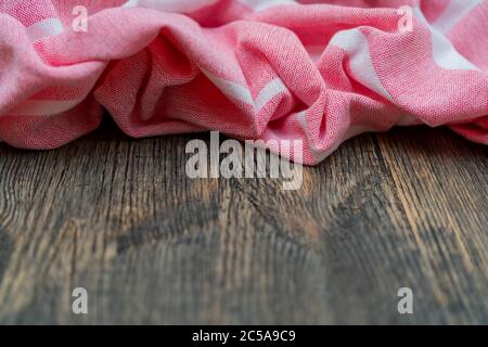 Red and white kitchen towel lies on wooden table. Texture of painted ...