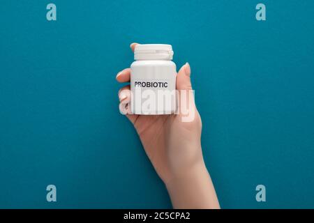 top view of container with probiotic lettering near pills on white ...