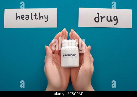 top view of container with probiotic lettering near pills on white ...