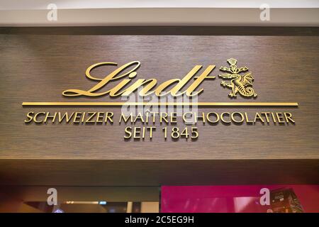 Lindt shop and sign in Berlin Germany and cafe with seats outside sign ...