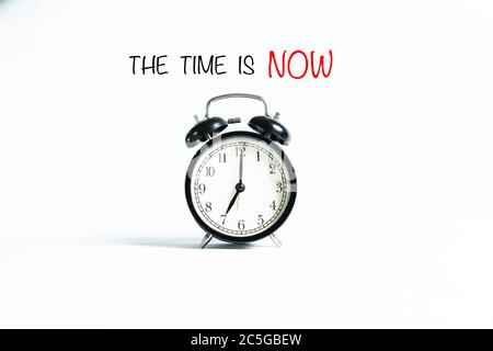 “THE TIME IS NOW” wordings with alarm clock against white background ...