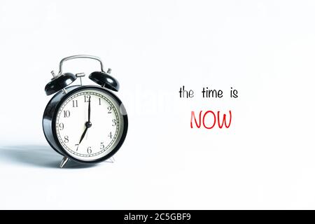 “THE TIME IS NOW” wordings with alarm clock against white background ...