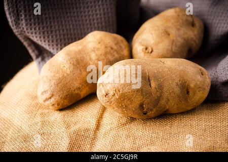 Fresh Potatoes on a rag with dark background Stock Photo - Alamy