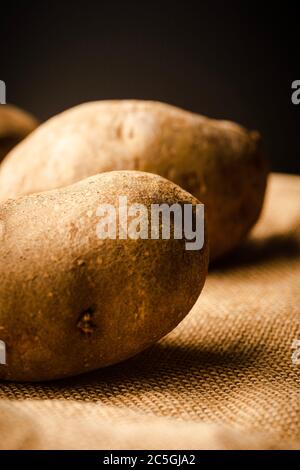 Fresh Potatoes on a rag with dark background Stock Photo - Alamy