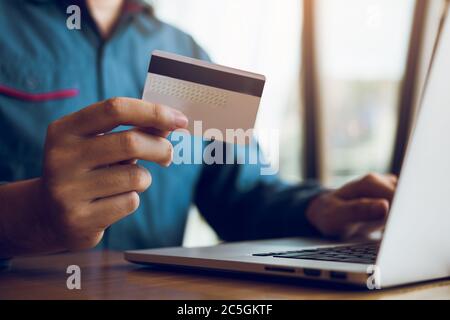 Man with wallet and credit cards using laptop in bedroom, closeup Stock ...