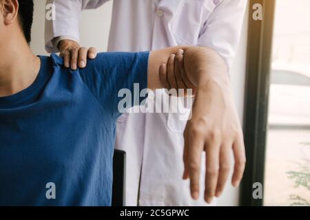 Physical therapists press to the patient shoulder check for pain Stock ...
