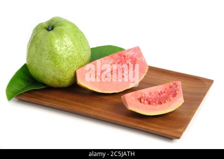Isolated guavas. Cut guava tropical fruits with yellow skin and pink ...