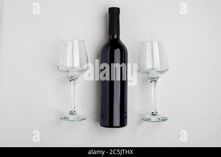 Overhead angled view of a large bottle of red wine, drinking glasses on ...