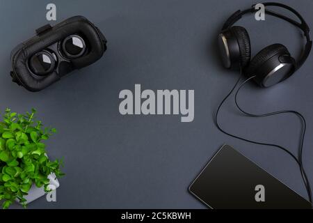 Virtual reality glasses and tablet with headphones on a gray background ...