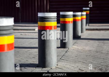 Gray warning bollards with red stripes at the parking zone Stock Photo ...