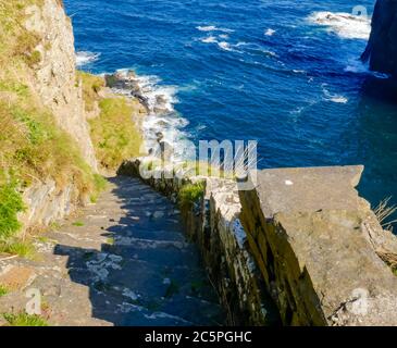 Steep stone steps leading down the side of the cliff at Tintagel Castle ...