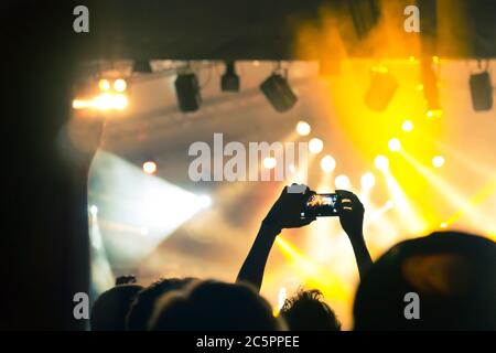 Concert crowd point of view in front of a lit stage for a night ...