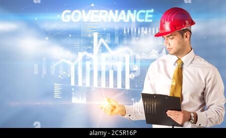 Handsome businessman with helmet drawing GOVERNANCE inscription ...