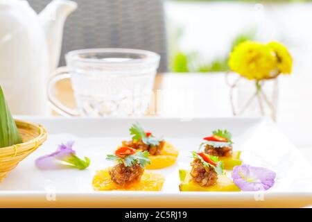 Thai Dessert name is " MA HOR " on the dish and they are on the table ...