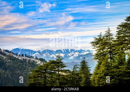 A scenic village in the backdrop of the snowcapped Himalayan mountains ...