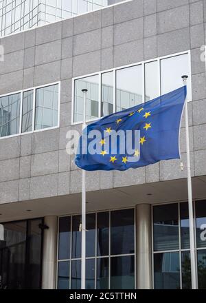 European Union flags flap in the wind as people walk by European ...