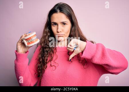 Angry woman showing teeth and holding fist looking nervous to camera ...