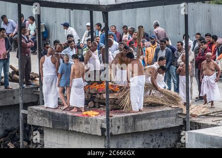 A Hindu cremation rite in Nepal. The samskara shows the body wrapped in ...