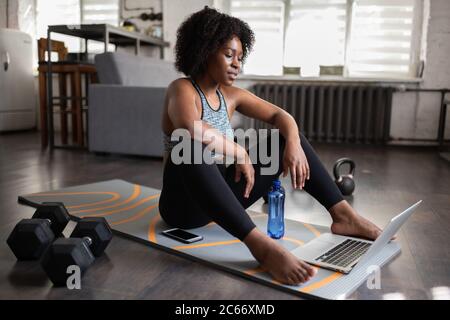tired woman sitting on floor and looking at paper plane at home Stock ...