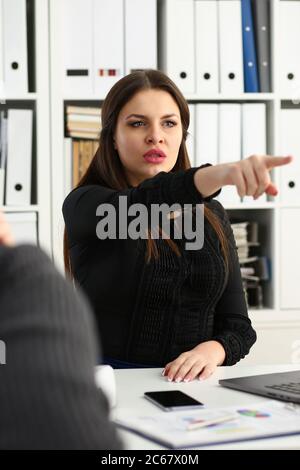 Young executive officer scolding his worker isolated on a black ...