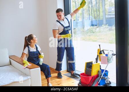 Team of professional janitors in uniforms cleaning room Stock Photo - Alamy
