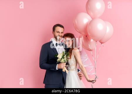 White bearded man posing with balloons and heart gift box isolated over ...